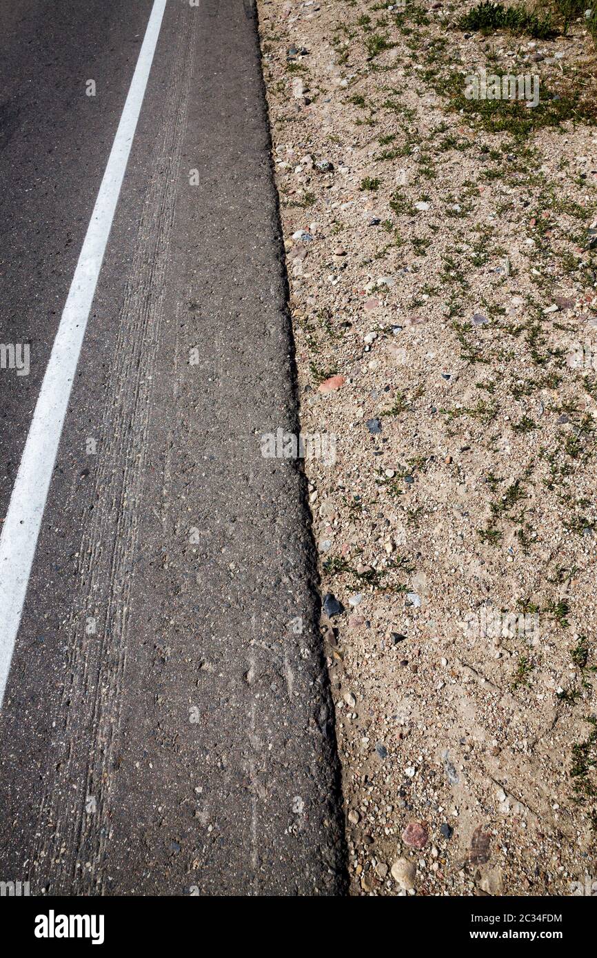 white road markings in the form of a white line drawn on black asphalt ...