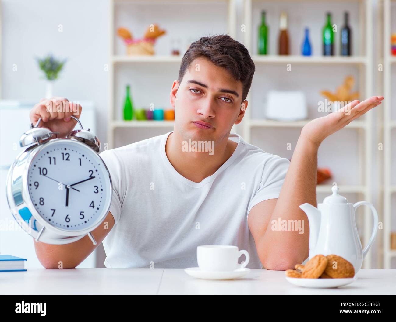 Man with alarm clock falling asleep at breakfast Stock Photo - Alamy