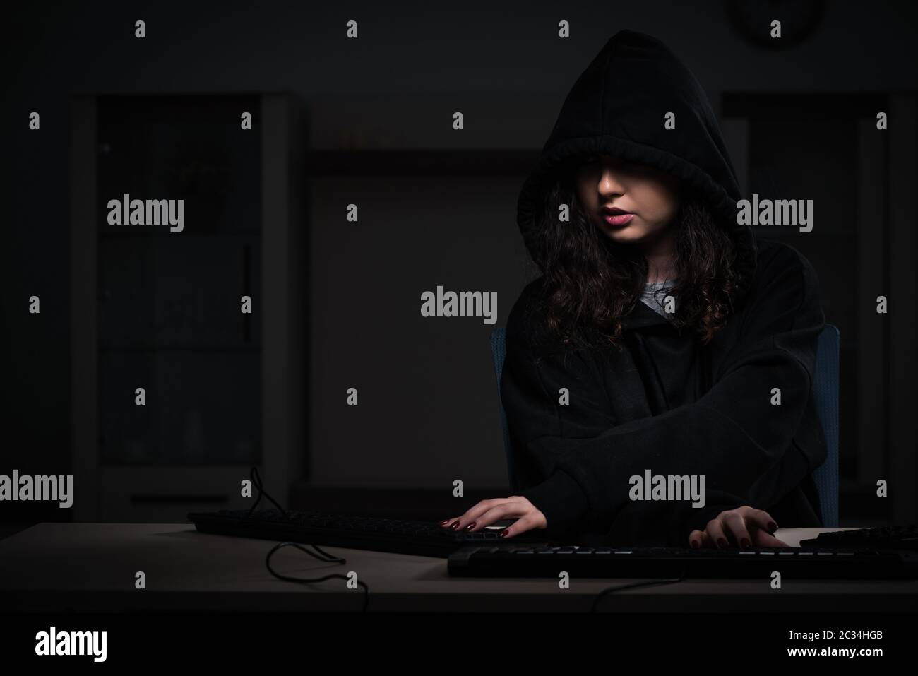 Female hacker hacking security firewall late in office Stock Photo - Alamy