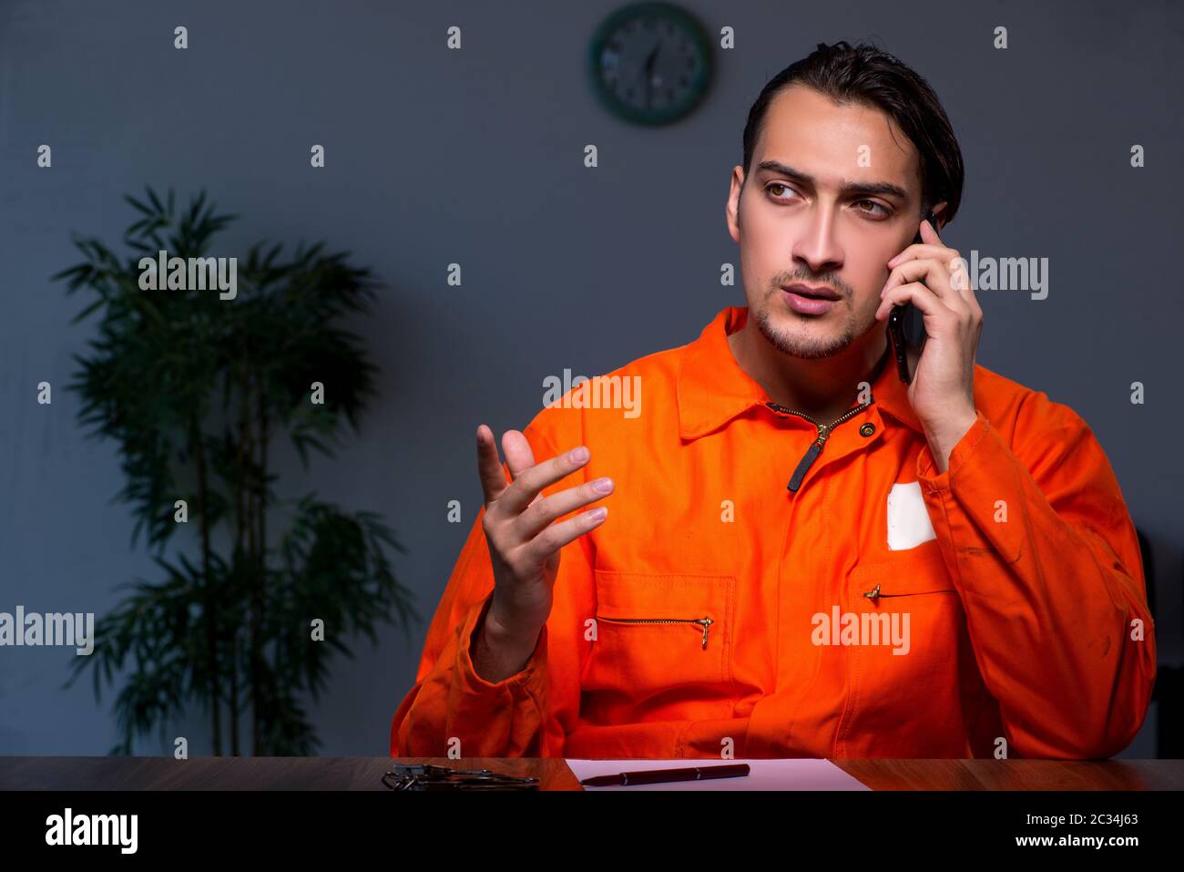 Young convict man sitting in dark room Stock Photo - Alamy