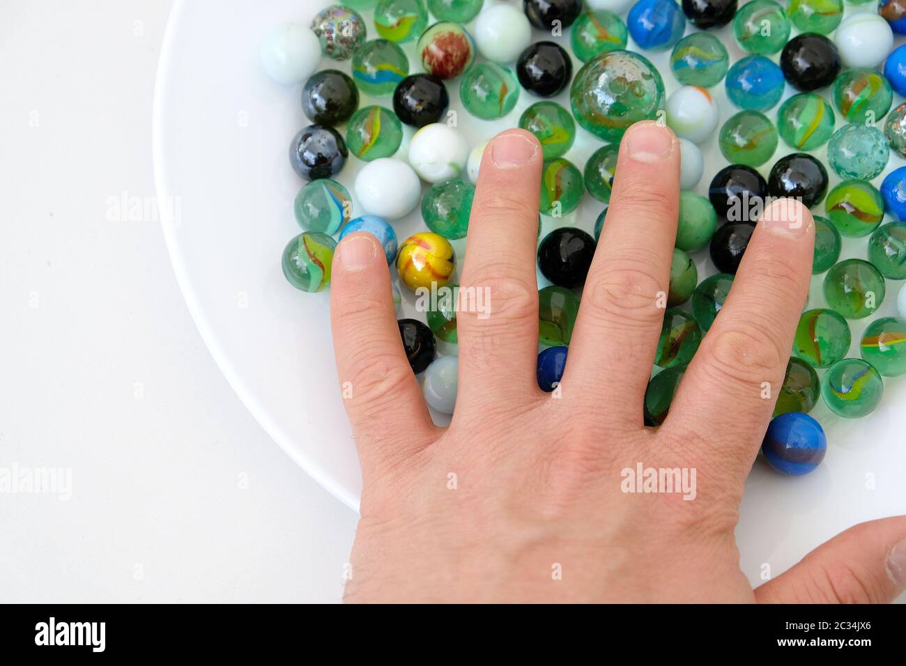 fun game for kids with colored glass marbles, glass balls Stock Photo ...