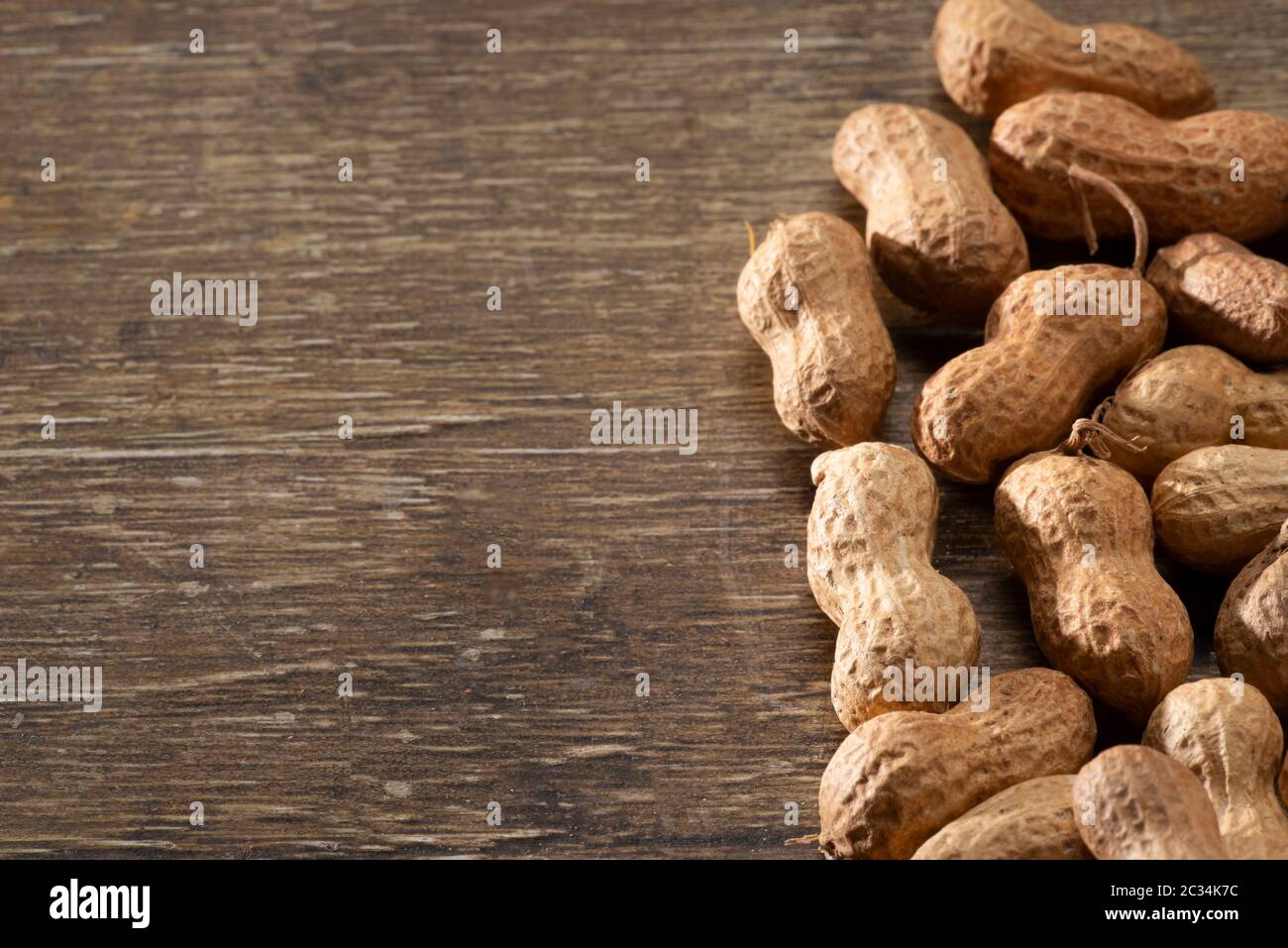 A row of peanuts in the shell making border on a brown background, Top ...