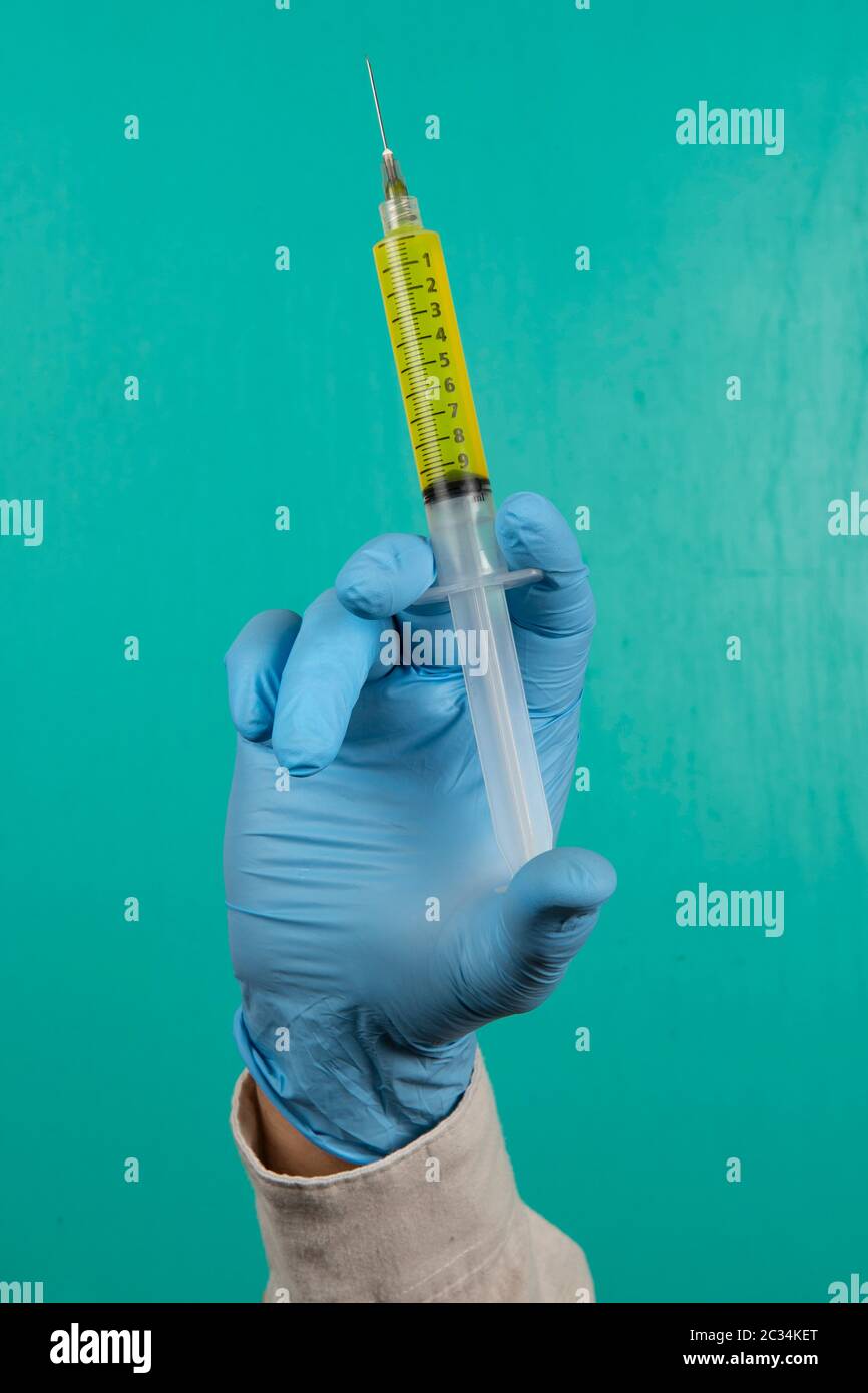 healthcare professional holding a syringe ready to give the injection ...