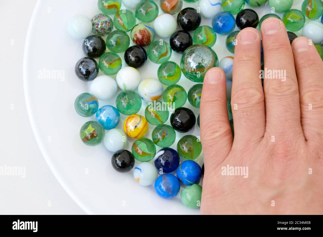 fun game for kids with colored glass marbles, glass balls Stock Photo ...