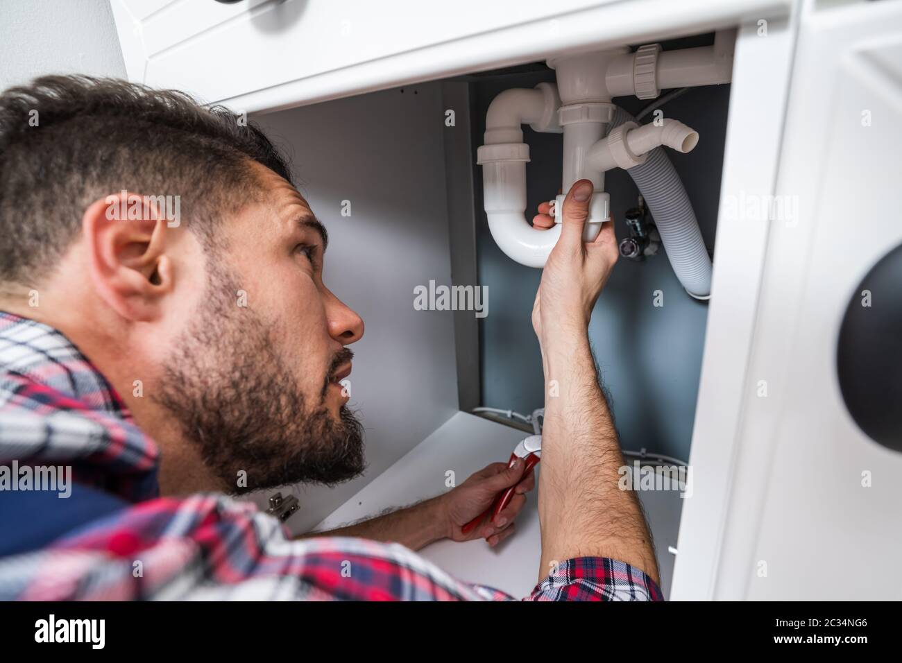 Handyman in uniform fixing pipes hi-res stock photography and images ...