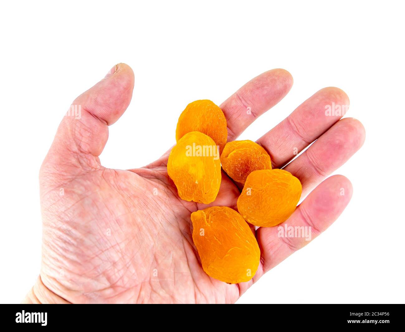 Dried apricots in a hand on a white background with place for text ...