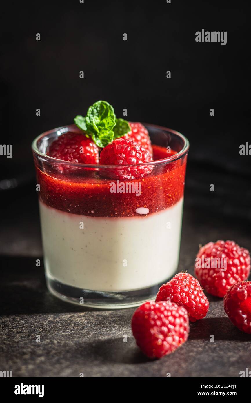 Italian dessert panna cotta with raspberries on black kitchen table ...