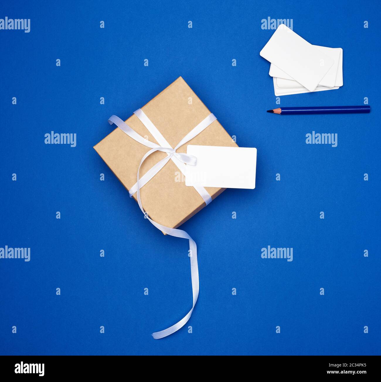 cardboard gift square box tied with a white thin ribbon and white empty ...