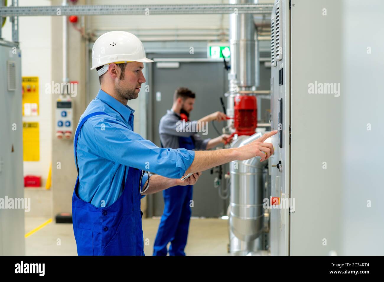 two worker in blue work clothes in industrial plant Stock Photo - Alamy