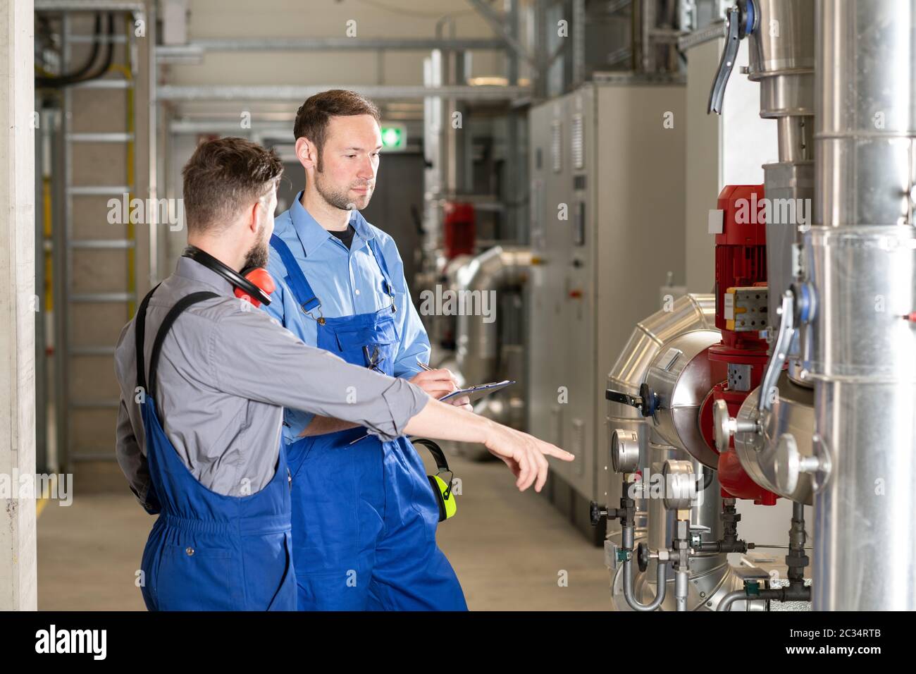 two worker in blue work clothes in industrial plant Stock Photo - Alamy