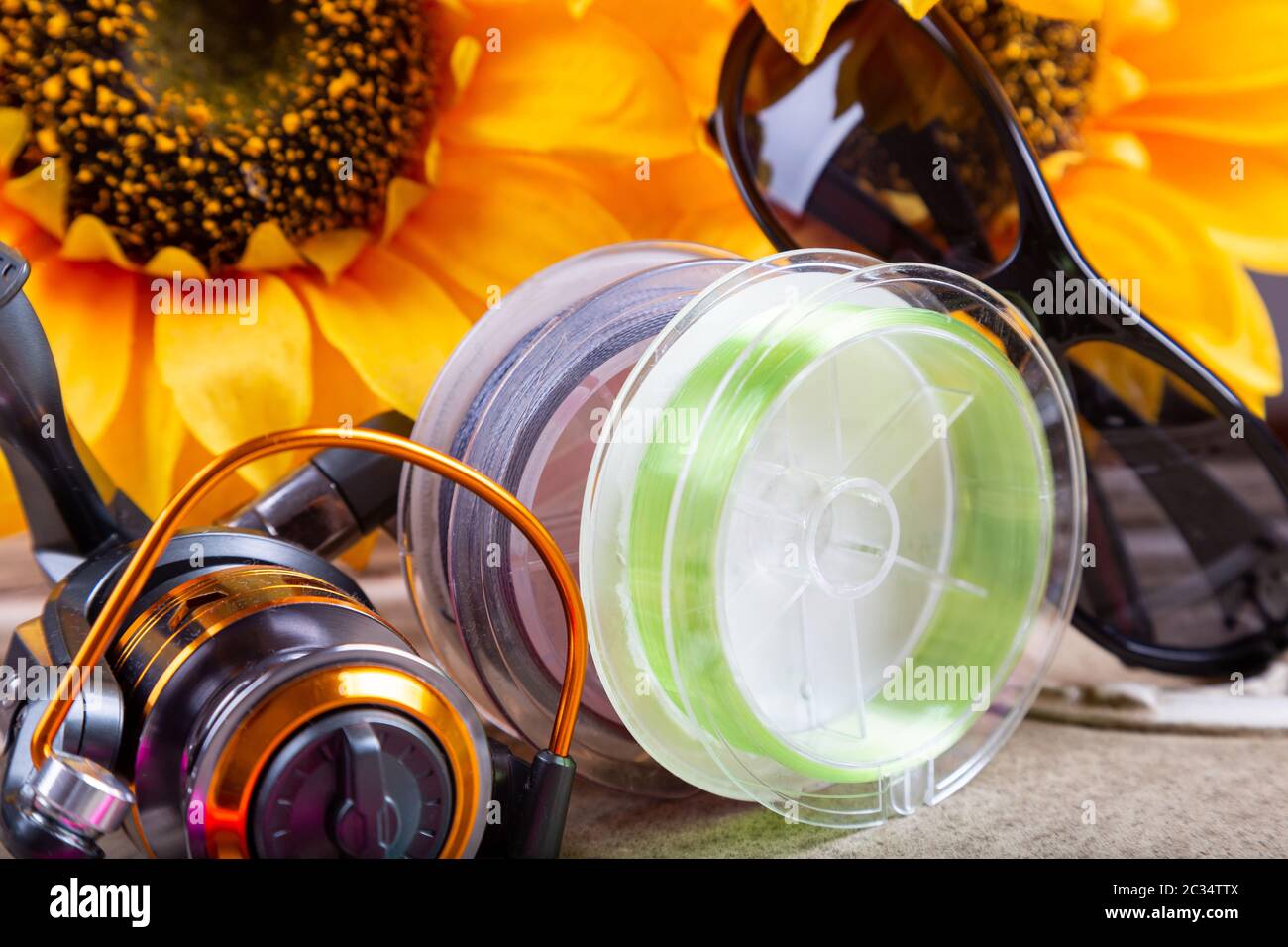 Fishing tackles, lines and reel with spring decoroation with sunflowers ...