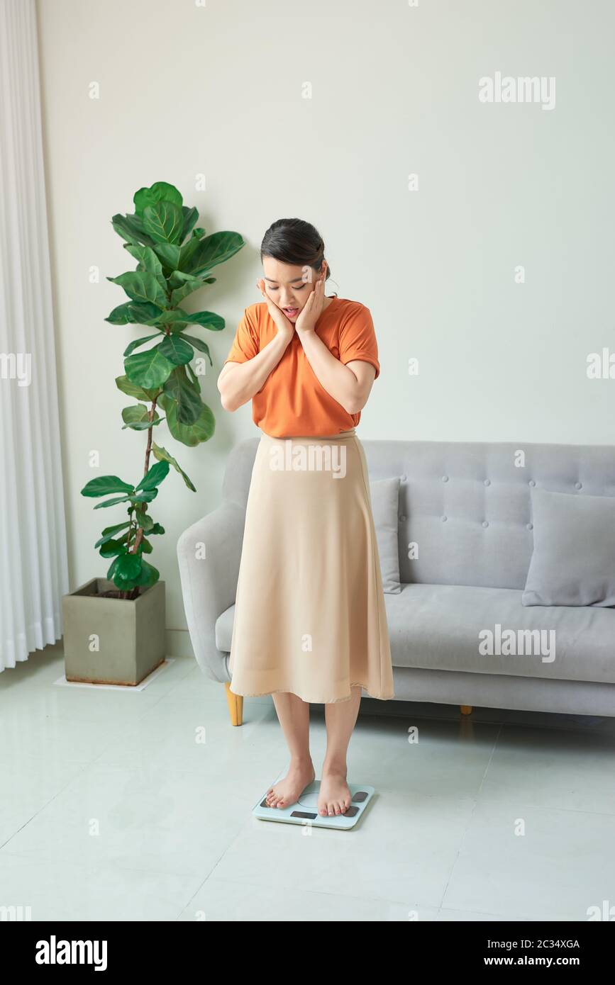 Beautiful young woman checking her weight on a simple white scale Stock ...