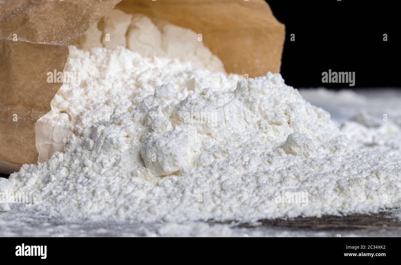 a small paper bag with durum wheat flour on the table, some of the ...