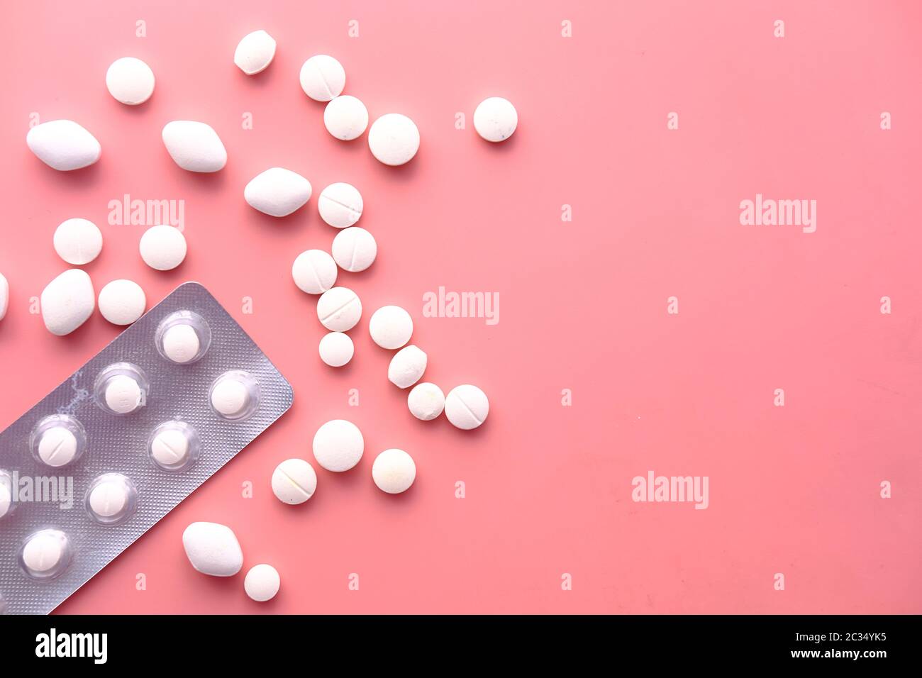 high angel view of white pills spilling on pink background Stock Photo ...