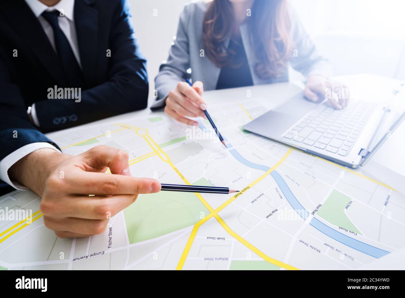 Two People Looking At City Map With Laptop At Table Stock Photo - Alamy