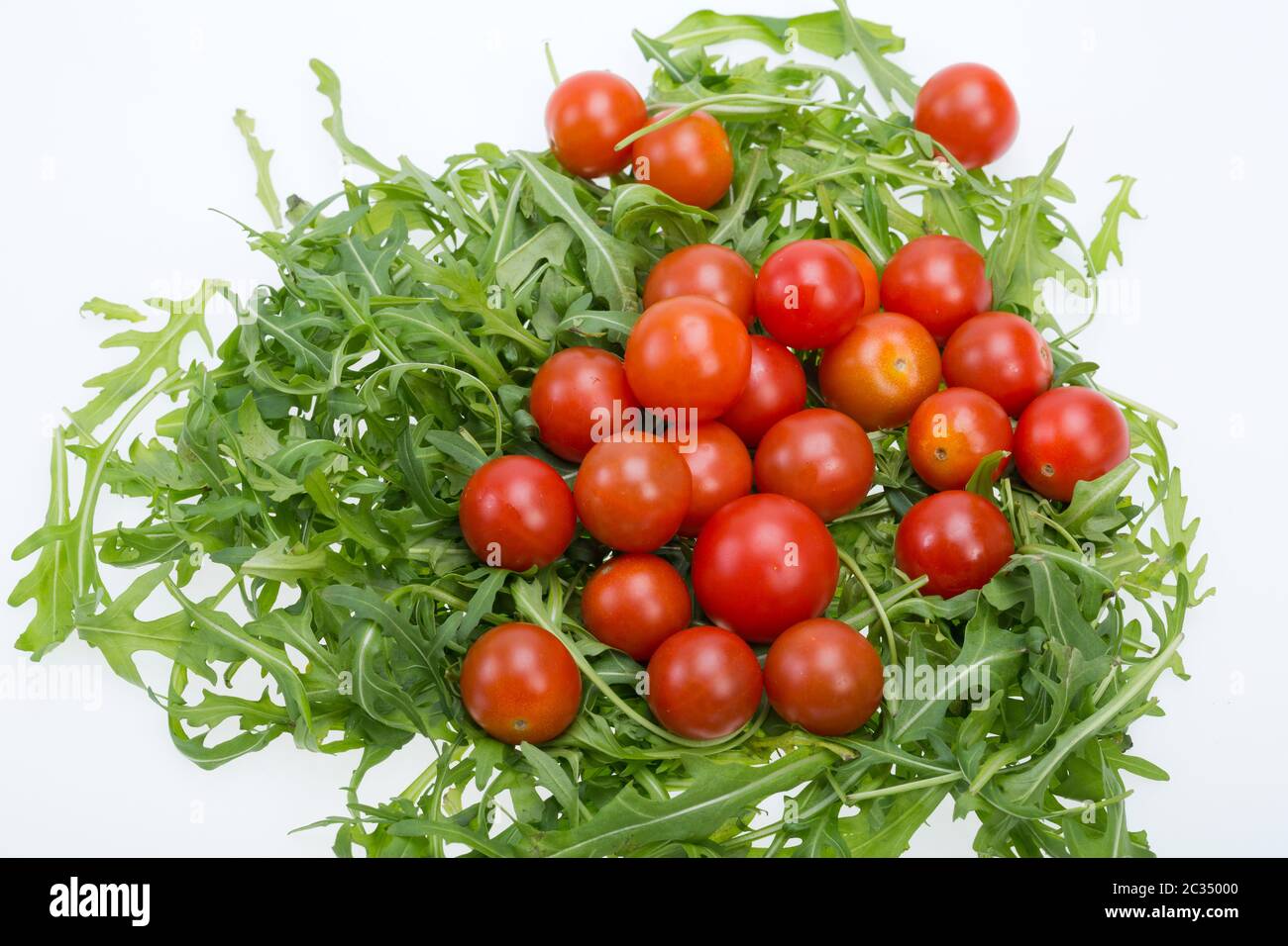 Heap of ruccola leaves and cherry tomatoes Stock Photo - Alamy