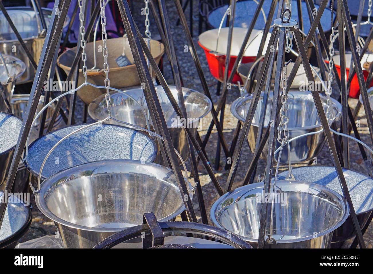 Many new metal cooking cauldrons with tripod legs Stock Photo - Alamy