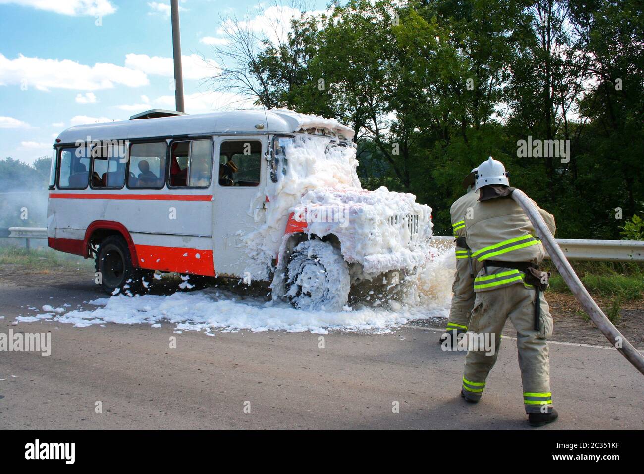 Firefighters extinguish a fire in a burning bus Stock Photo - Alamy