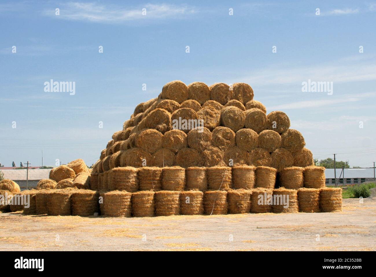 pyramid of hay with the blue cloudy sky in the background Stock Photo ...
