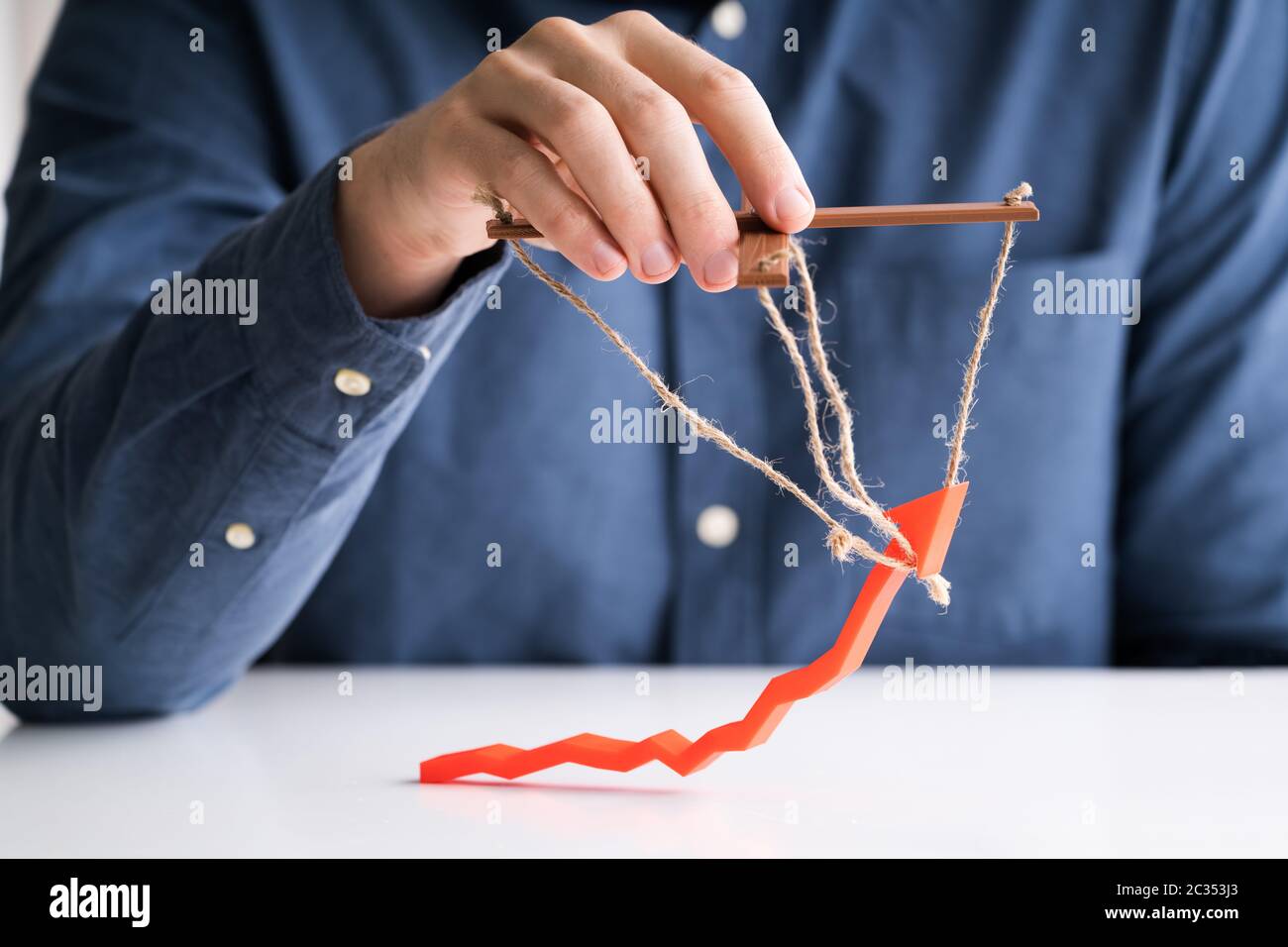 Businessperson's Hand Manipulating Red Arrow With Rope Stock Photo - Alamy