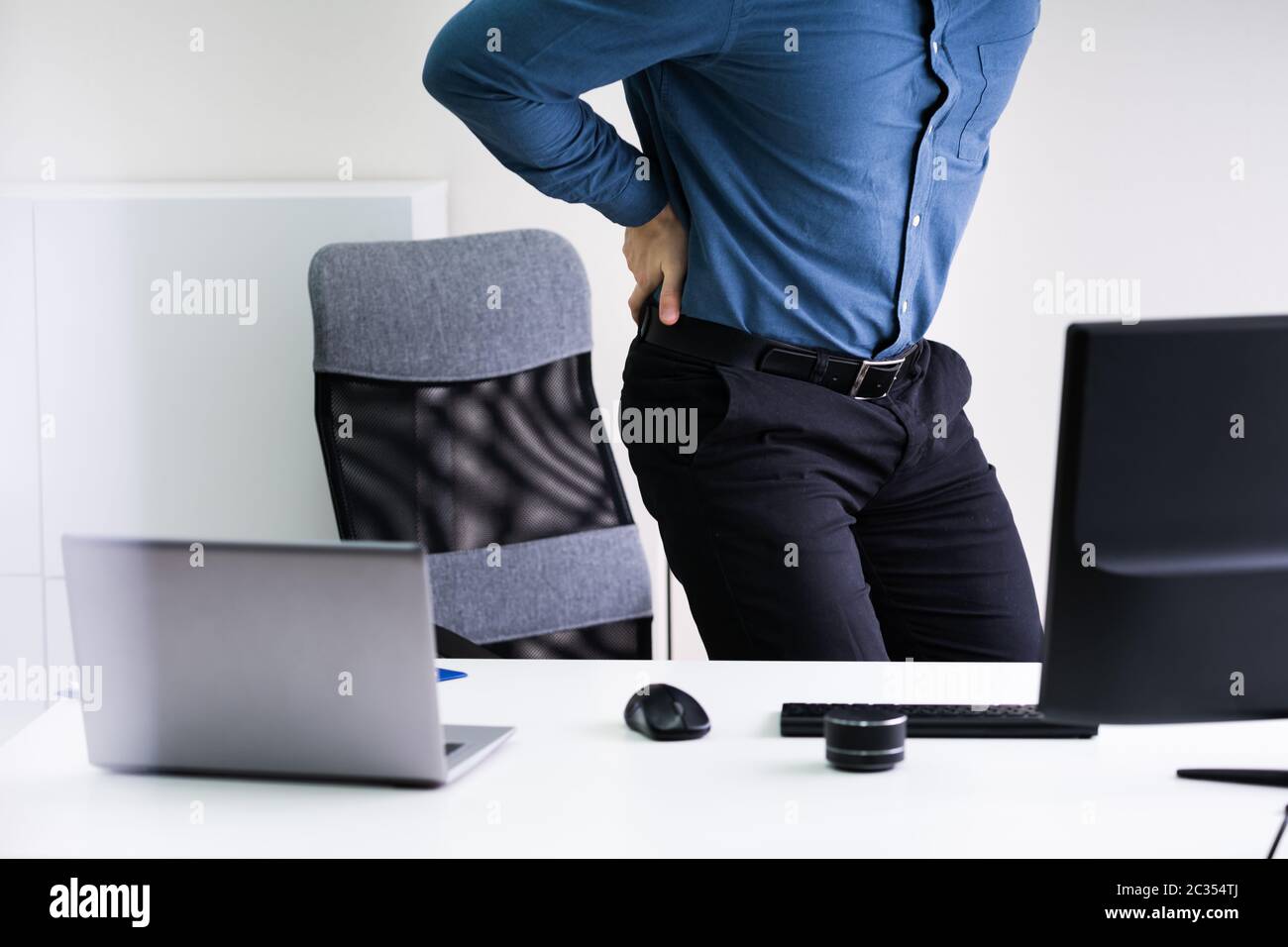 Businessman With Lower Back Ache Standing Near Office Desk Stock Photo ...