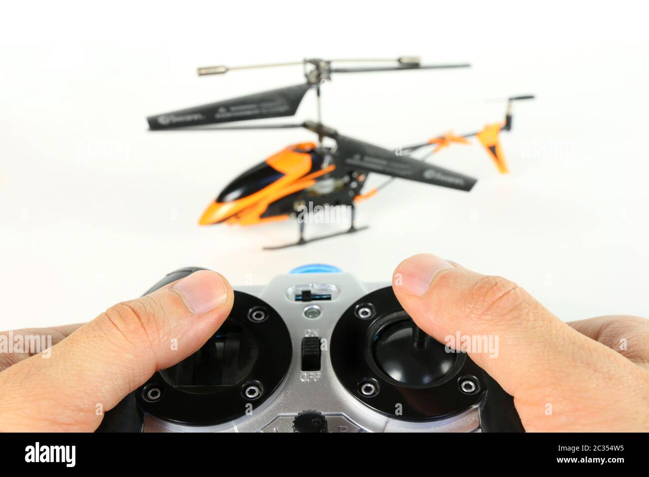 Guy playing with remote helicopter with radio remote control isolated ...