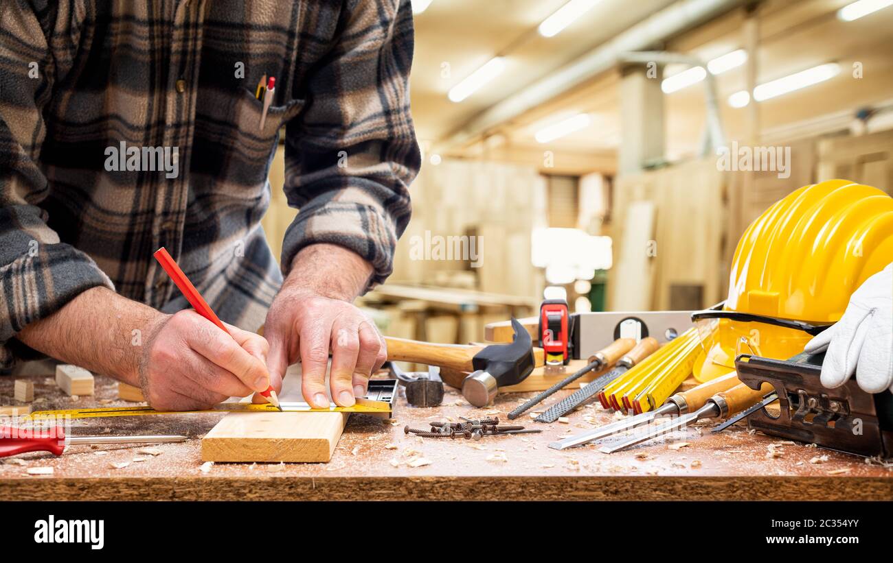 Close-up. Carpenter with pencil and carpenter's square draw the cutting ...