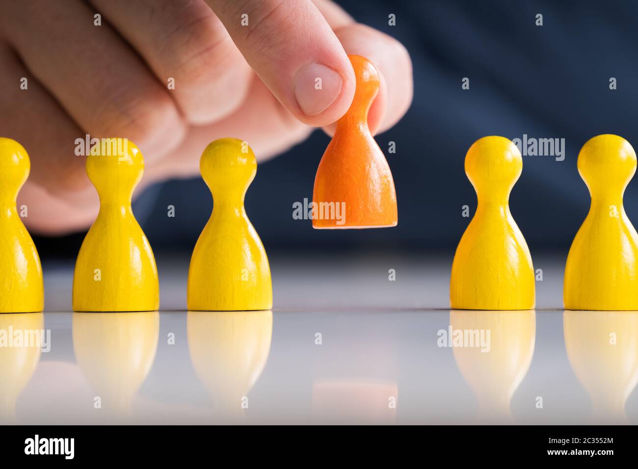 Close-up Of A Person Picking Orange Figure From The Row Over The ...