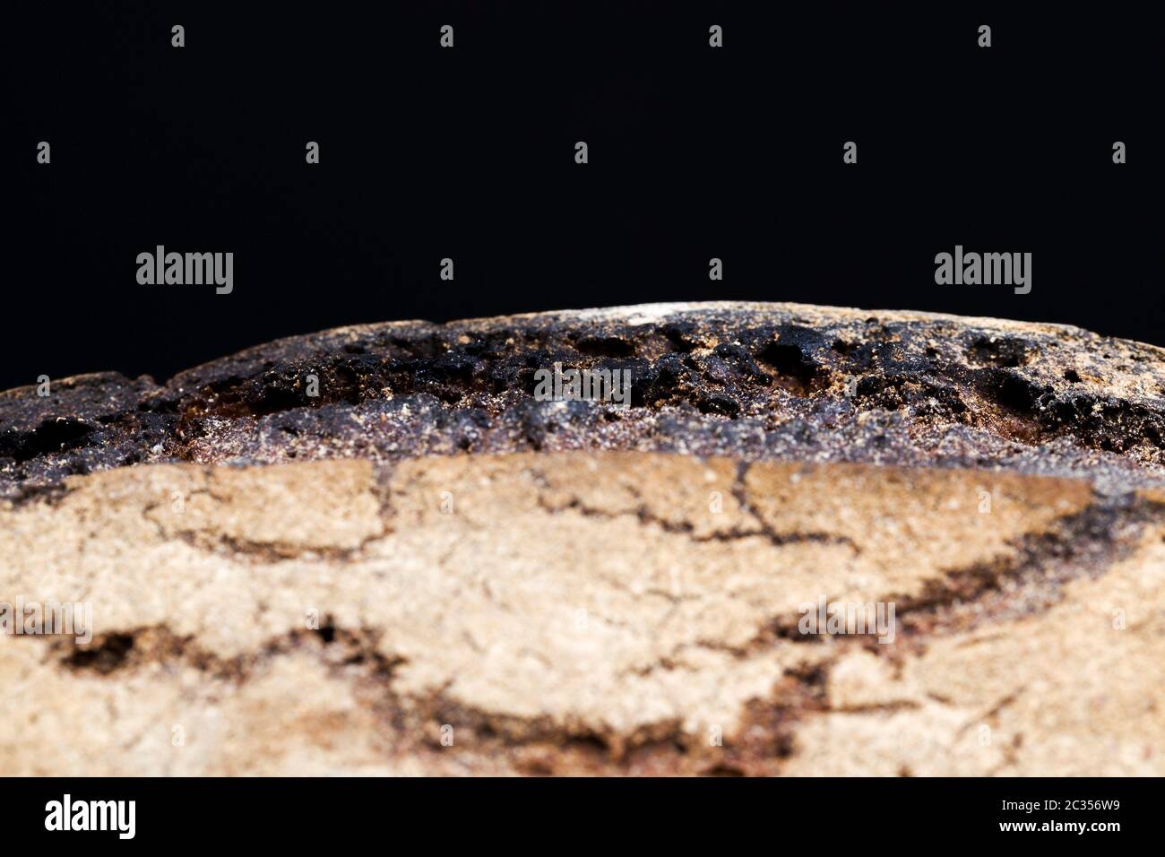 dark bread with a crisp crust on a wooden table, a loaf of whole ...
