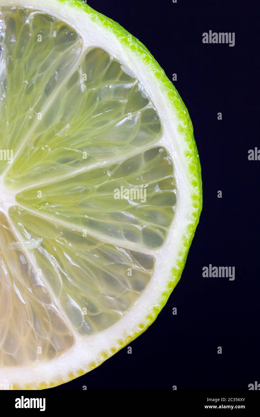 cut off a piece of green lime on a black background Stock Photo - Alamy