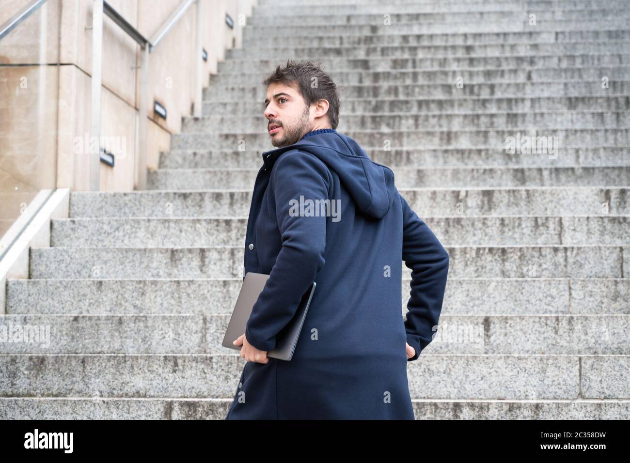 Young man Holding Computer Laptop Walking Up Stairs outdoor Stock Photo ...