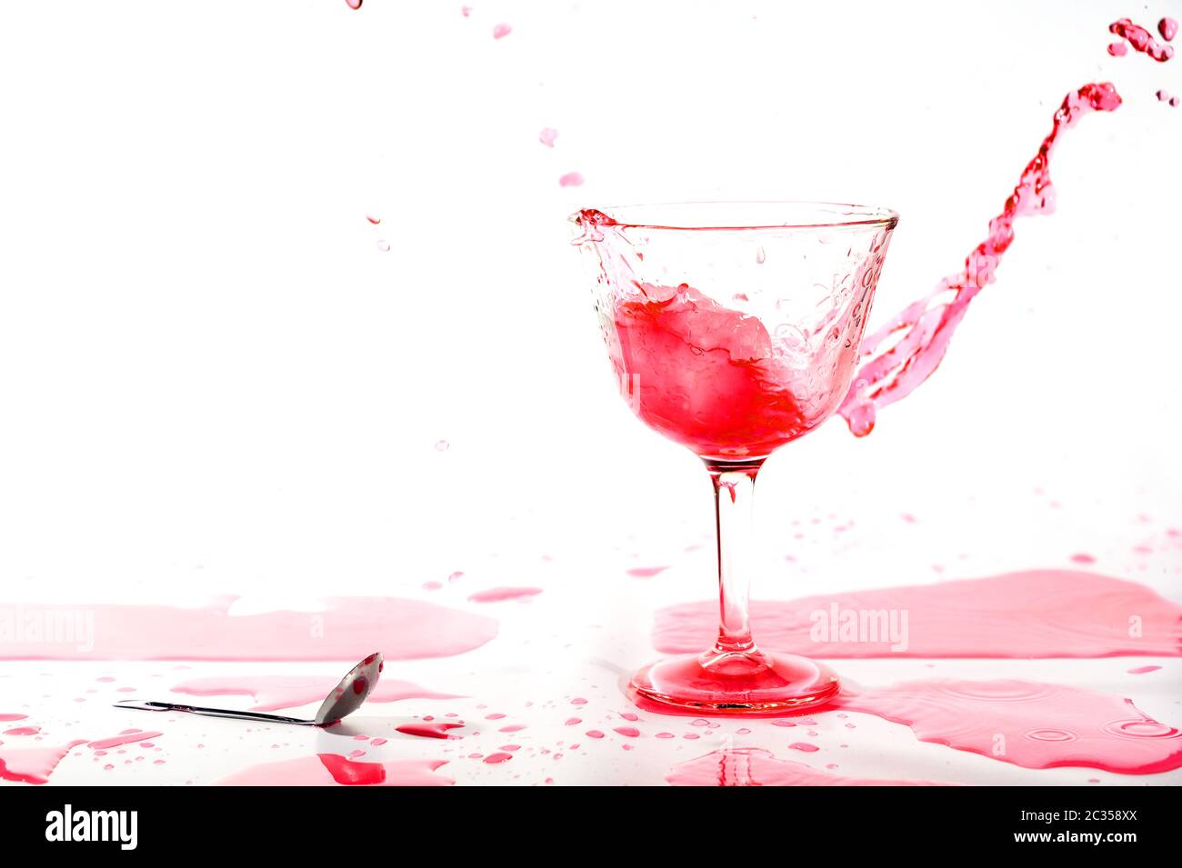 Red alcohol cocktail drink splash on white background Stock Photo - Alamy