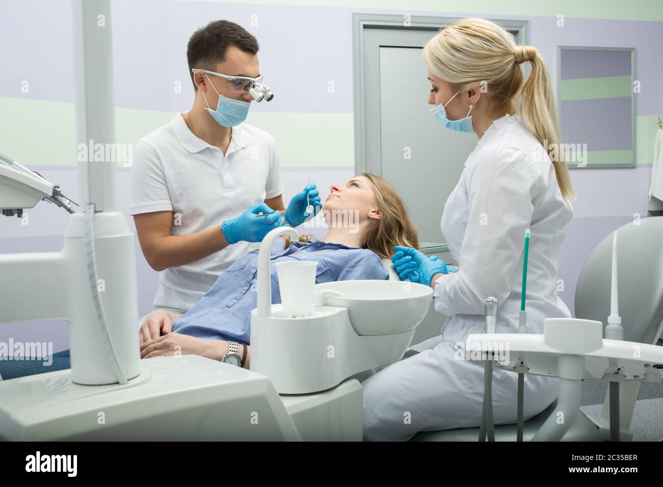 Dentist examining a patient's teeth in the dentist Stock Photo - Alamy