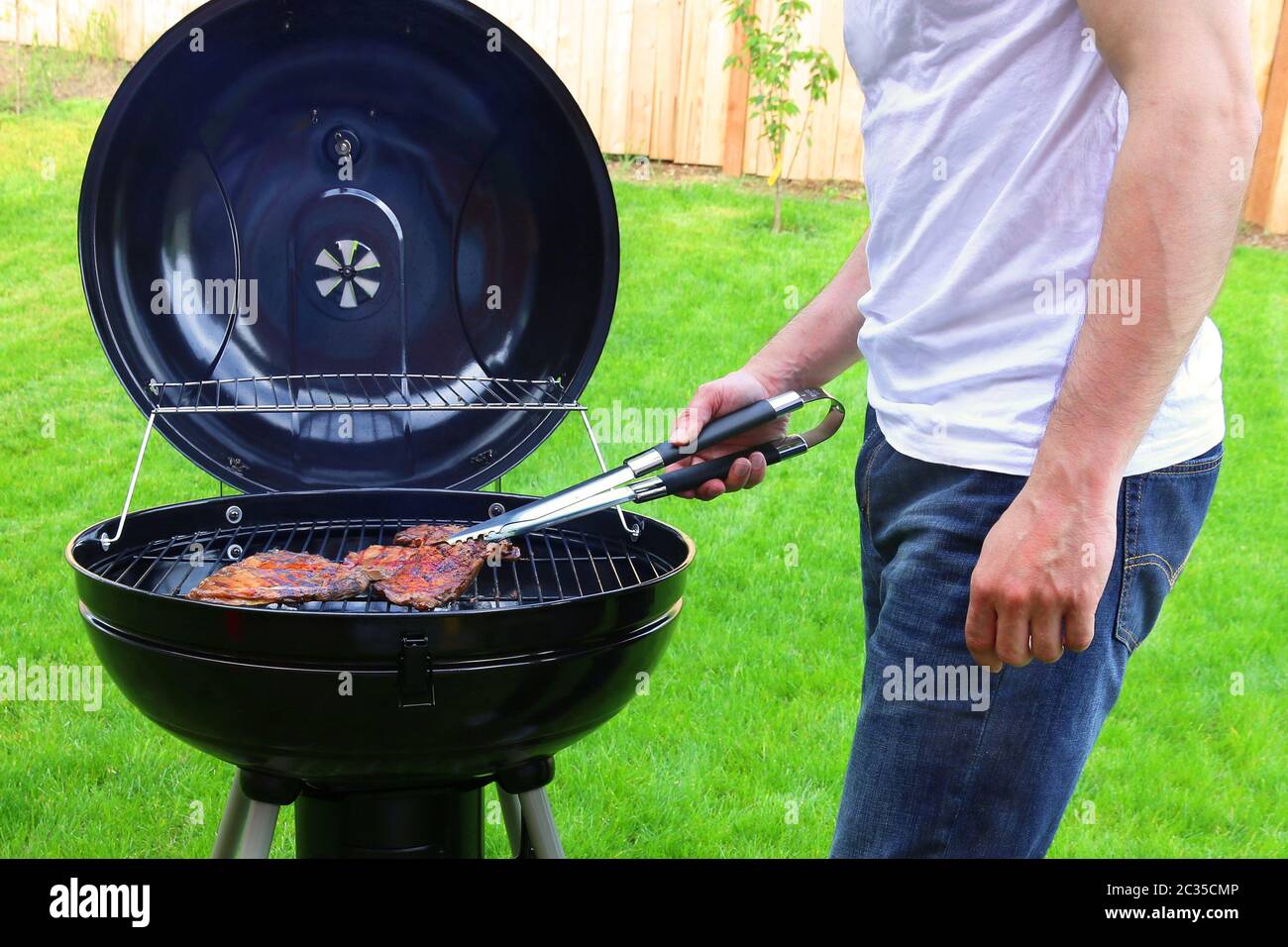Man roasting beef on BBQ grill Stock Photo - Alamy