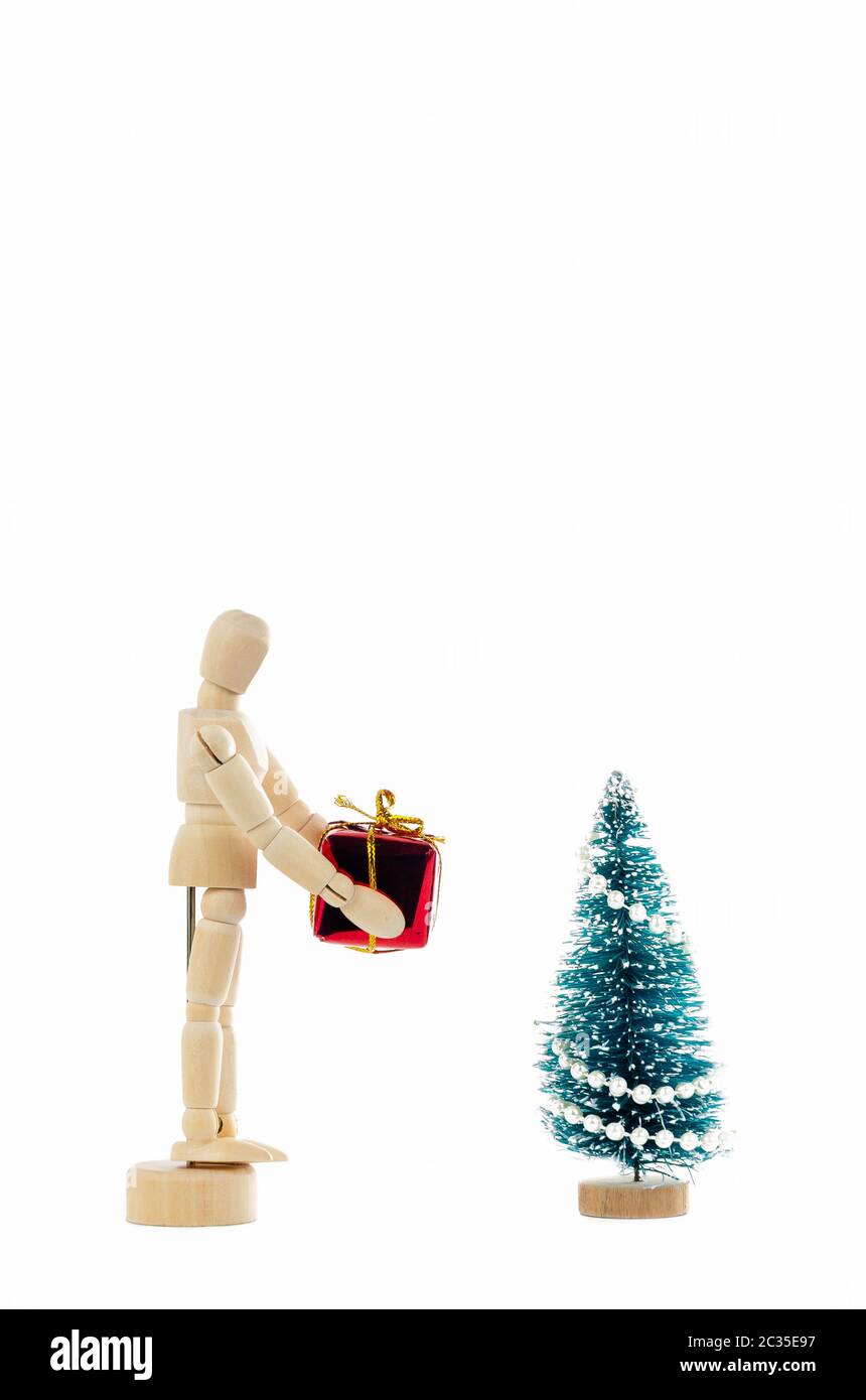 wooden dummy with christmas tree and gift on white background with copy ...