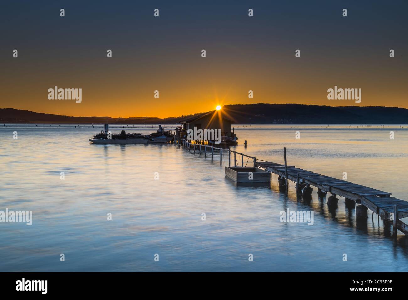 Sunrise with sunburst over the Oyster Shack and dilapidated wharf from ...