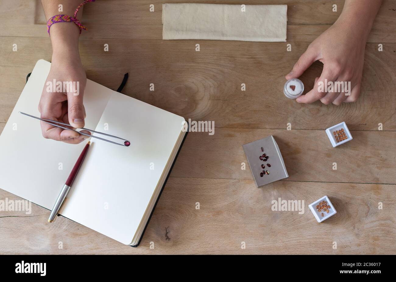 Top view of gemologist work table. Hand holding gemstone with jewelry ...