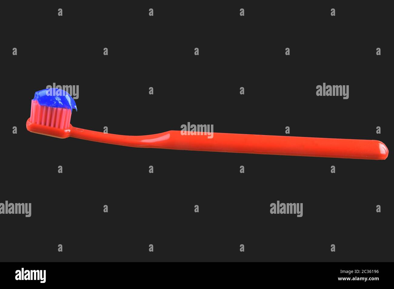 Red toothbrush and blue toothpaste isolated on the black background ...