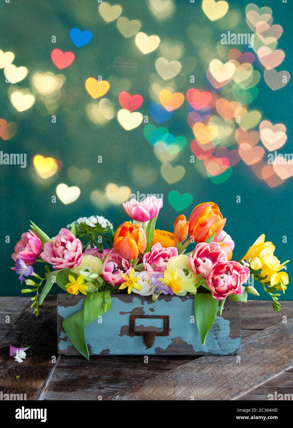 Colorful spring flowers with cheerful bokeh hearts Stock Photo - Alamy