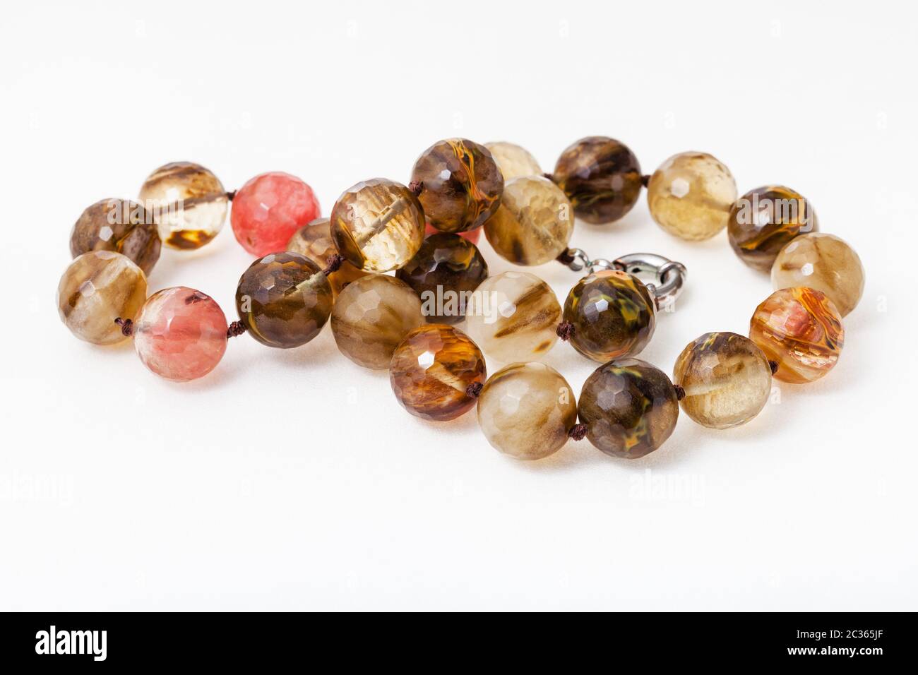 tangled necklace from translucent agate gemsones on white paper ...