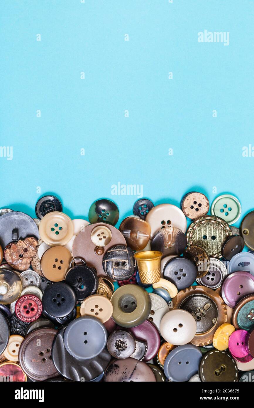 top view of pile of various buttons on blue background with blank ...