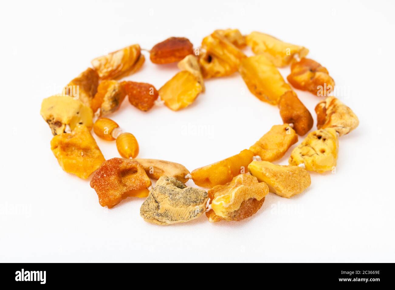 tangled necklace from natural raw yellow amber nuggets on white paper ...