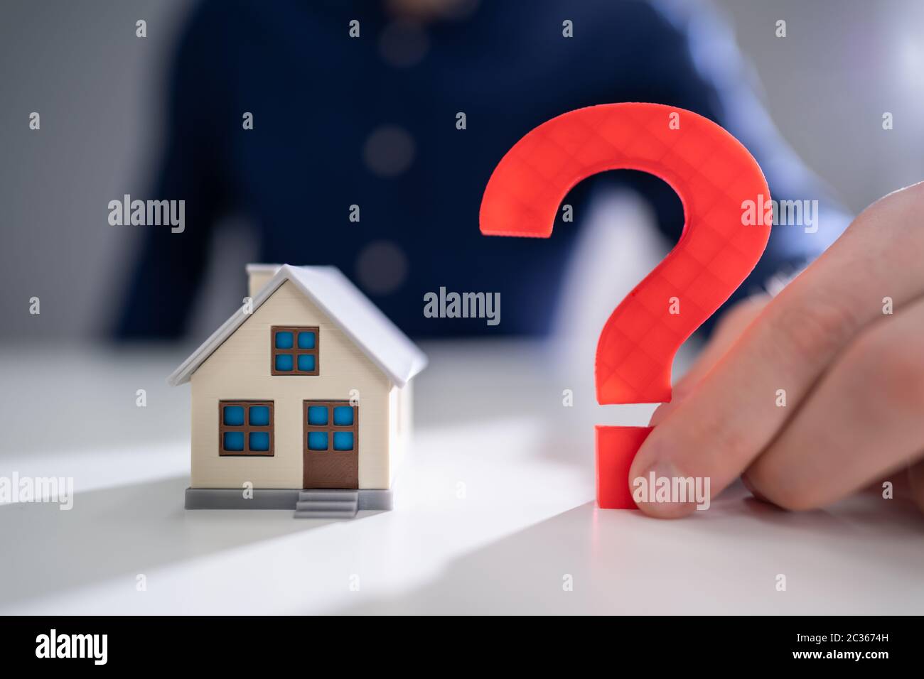 Man Holding Question Mark Next To House Model Stock Photo - Alamy