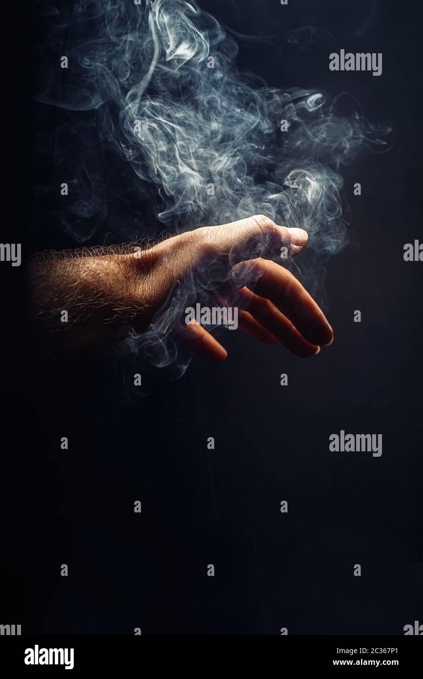 hand in smoke on black background Stock Photo - Alamy