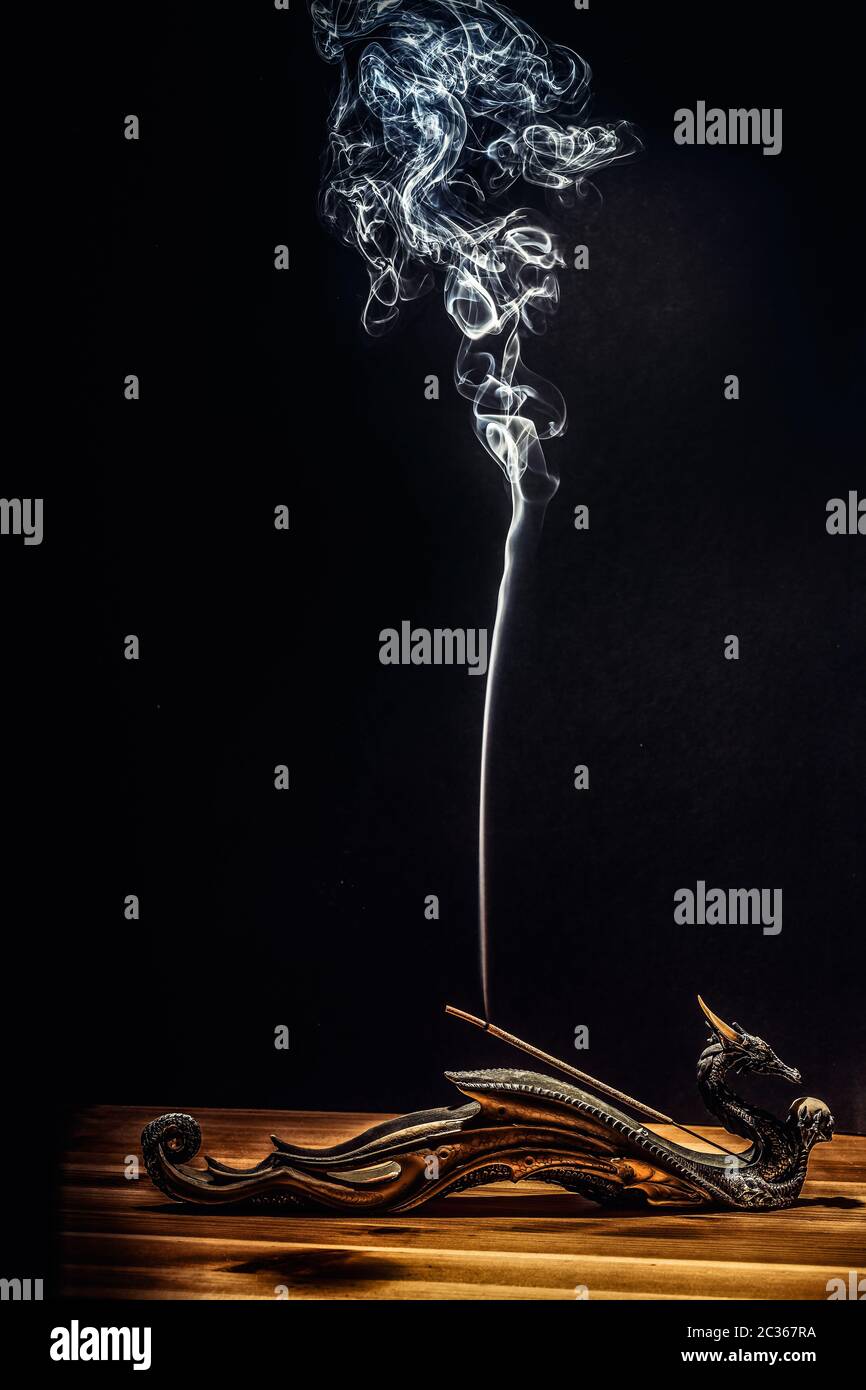 smoke incense stick, smoke on a black background Stock Photo - Alamy