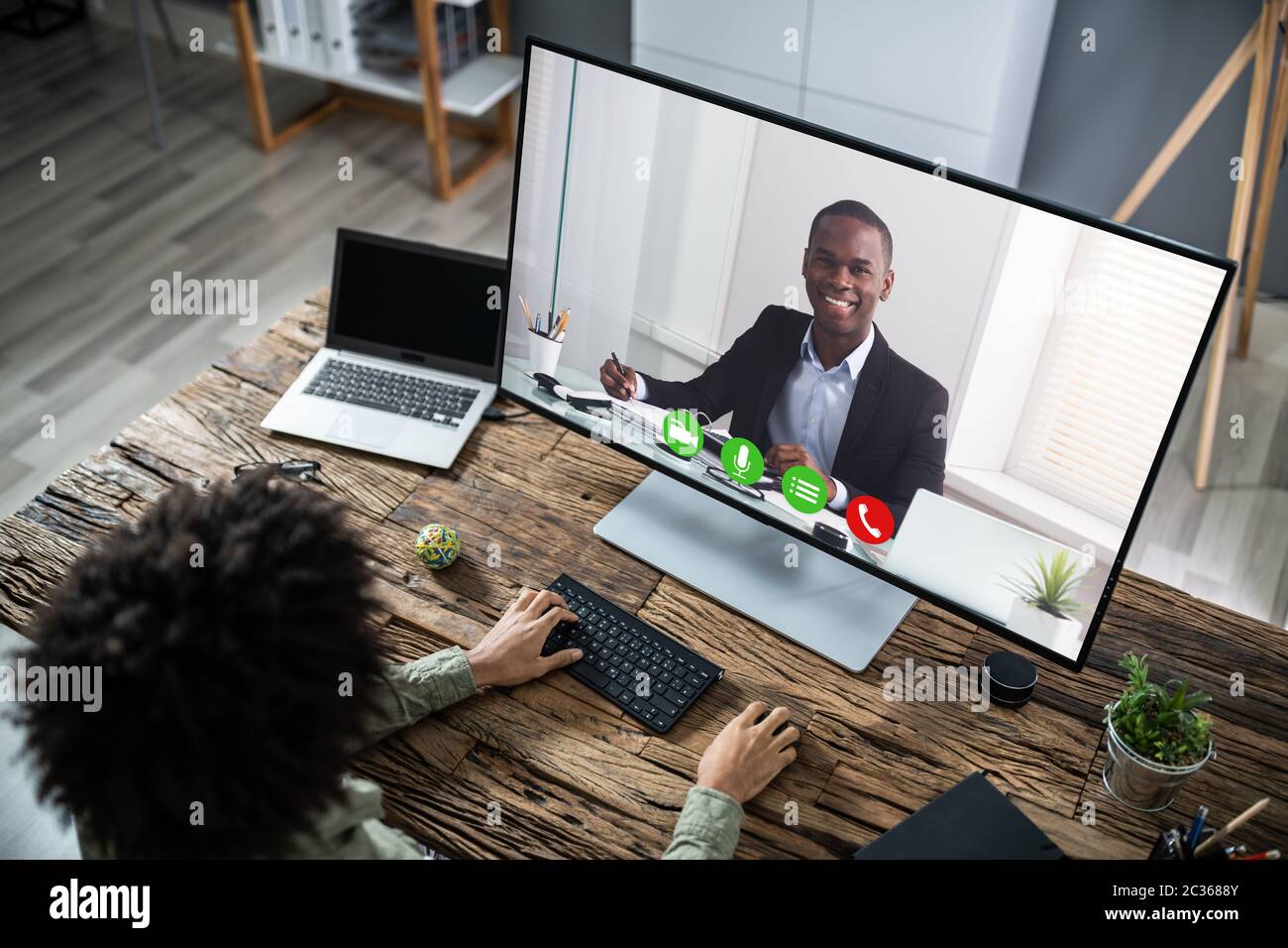 Businessman Sitting At A Desk Watching An Online Presentation On The ...