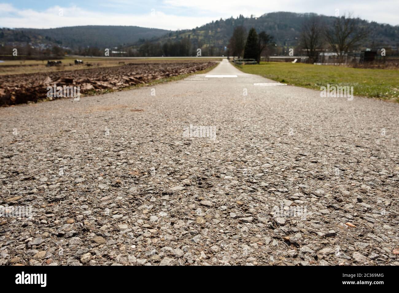 Tarred road in landscape with backlight and sharpness in foreground ...