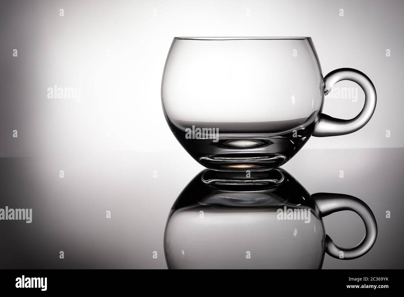 Glass mug for tea or bowle in backlight with reflection Stock Photo - Alamy