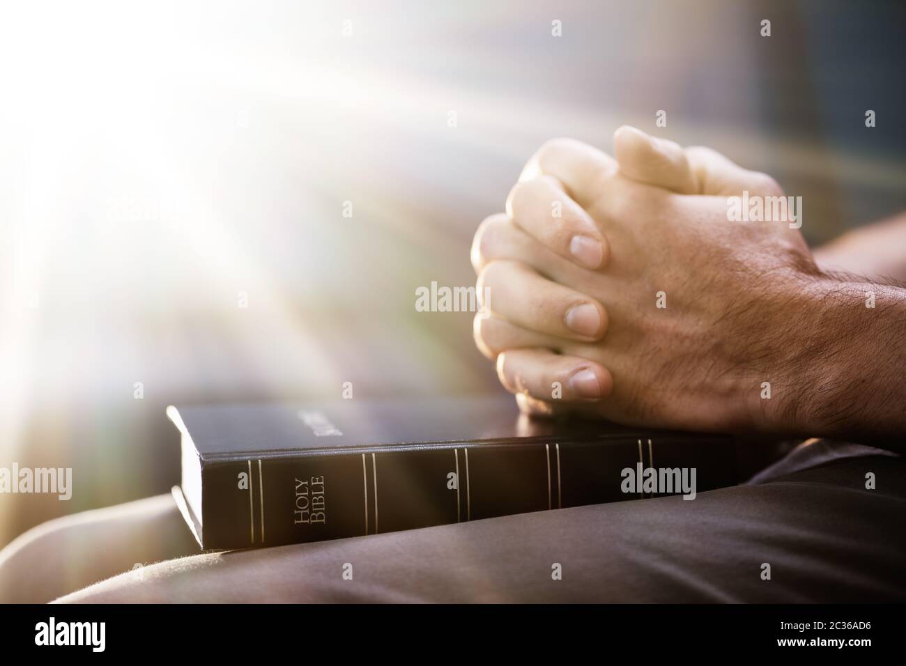 Sunlight Falling On Hand Over Bible While Praying Stock Photo - Alamy