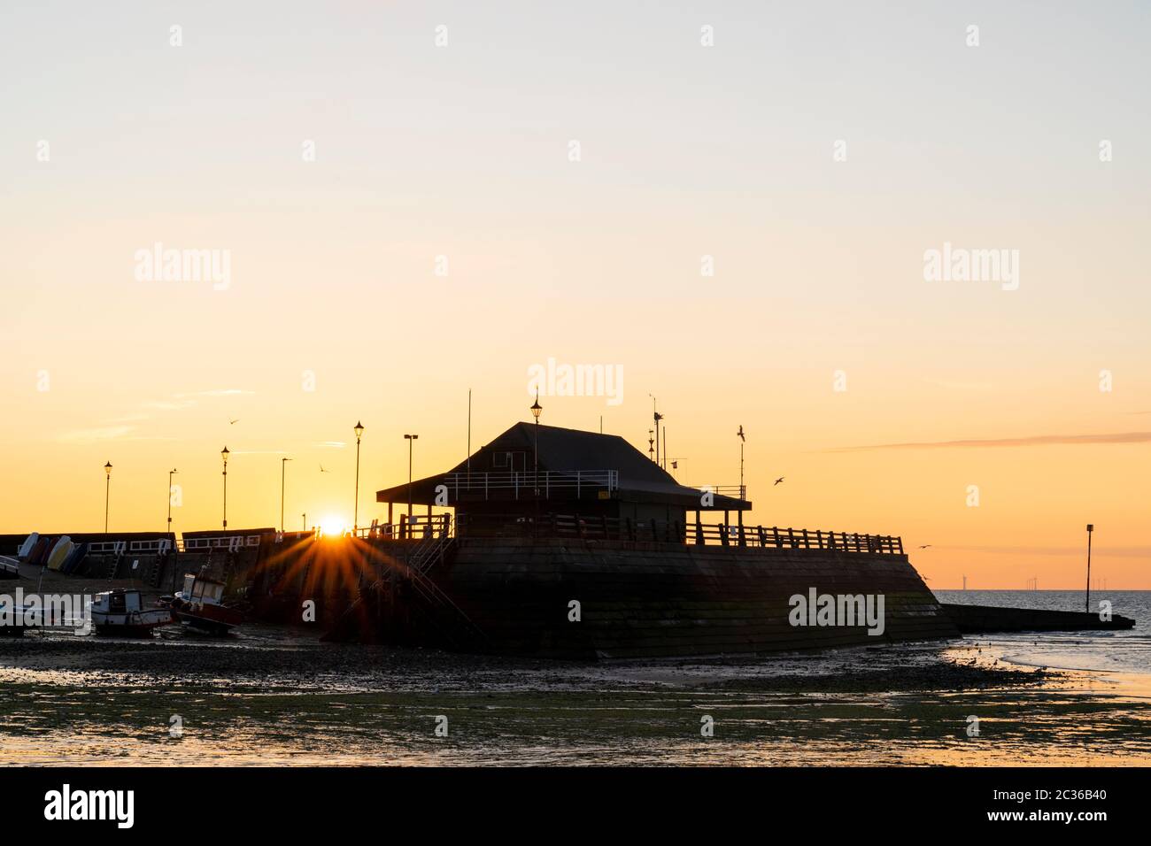 Sunrise over the single pier of Broadstairs harbour on the English Kent ...